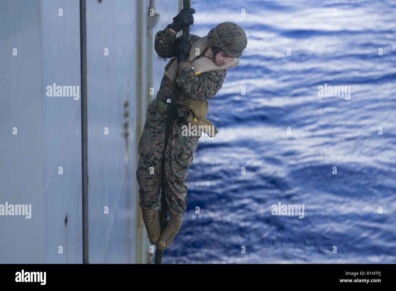 A Marine with the 31st Marine Expeditionary Unit fast ropes during ...