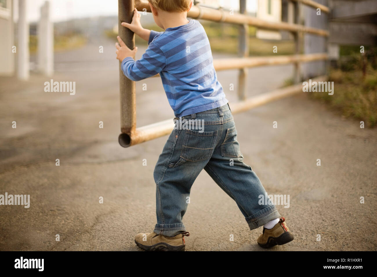 Little boy closing gate Stock Photo - Alamy