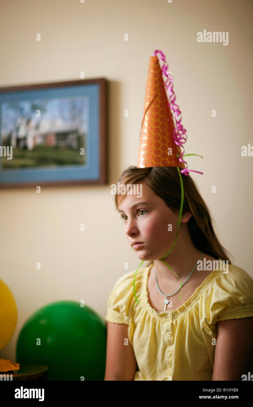 Serious girl wearing party hat Stock Photo - Alamy