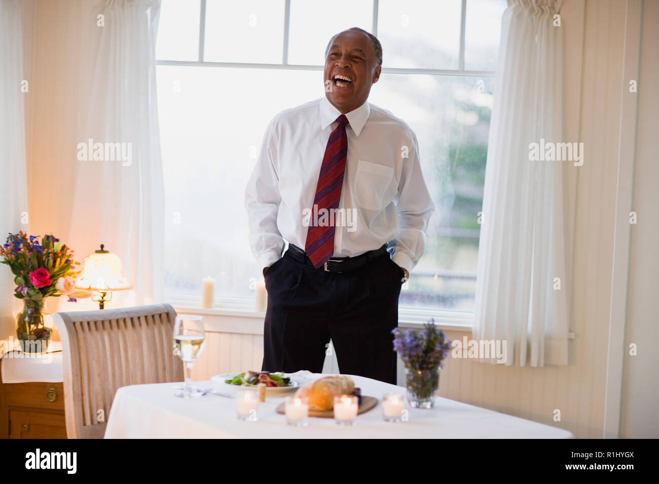 Elderly man laughing at dinner table hi-res stock photography and ...
