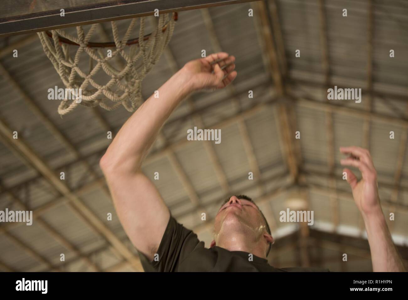 U.S. Marine Corps Capt. Jeffrey Ramey tosses the ball into the hoop ...