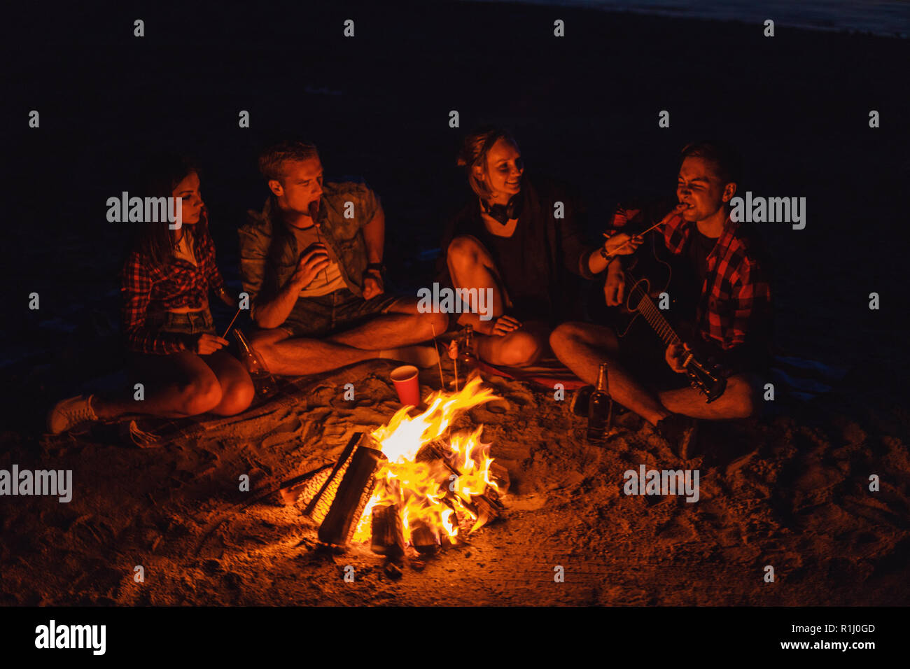young friends have picnic with bonfire on the beach Stock Photo - Alamy