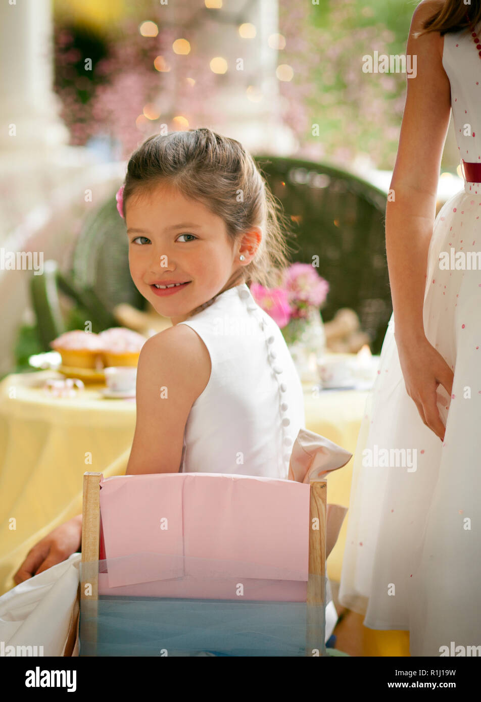 Portrait of a happy young girl looking over her shoulder and smiling ...