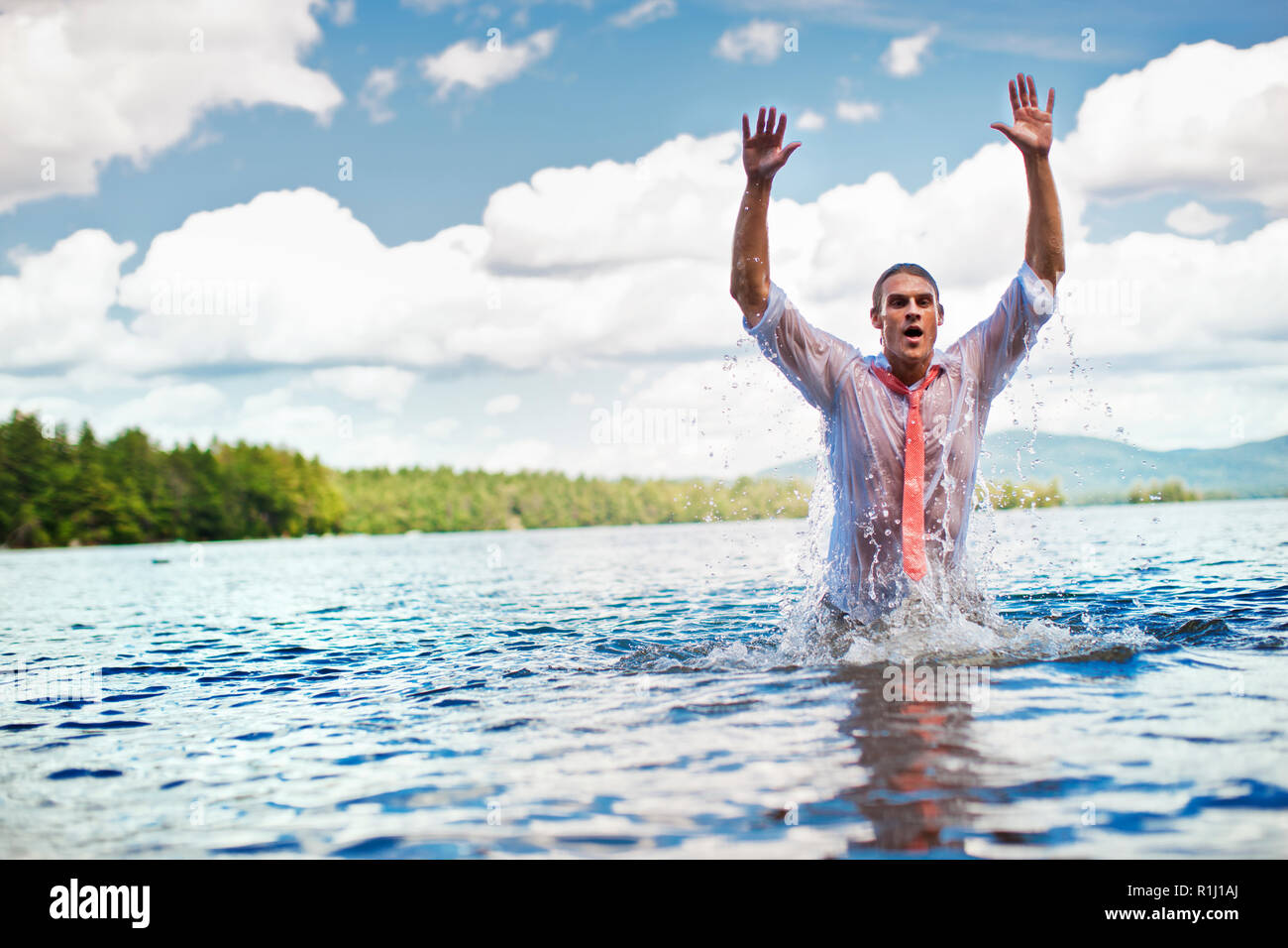 Fully clothed young businessman waist deep in a lake Stock Photo - Alamy