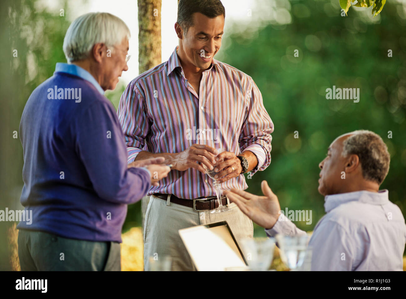 Smiling group of friends talking at a social gathering Stock Photo - Alamy
