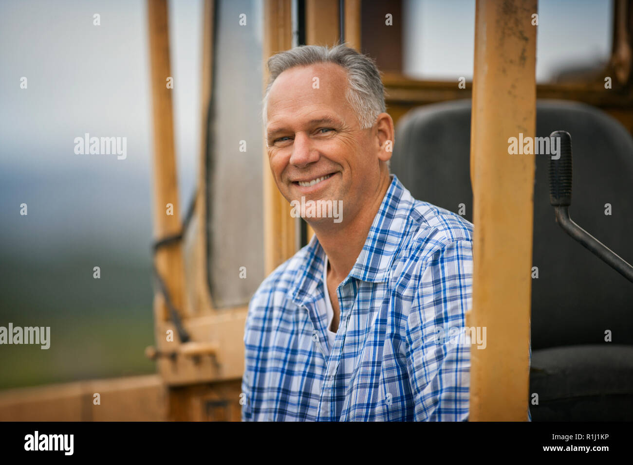 Portrait of a middle aged farmer sitting on a mechanical digger Stock ...