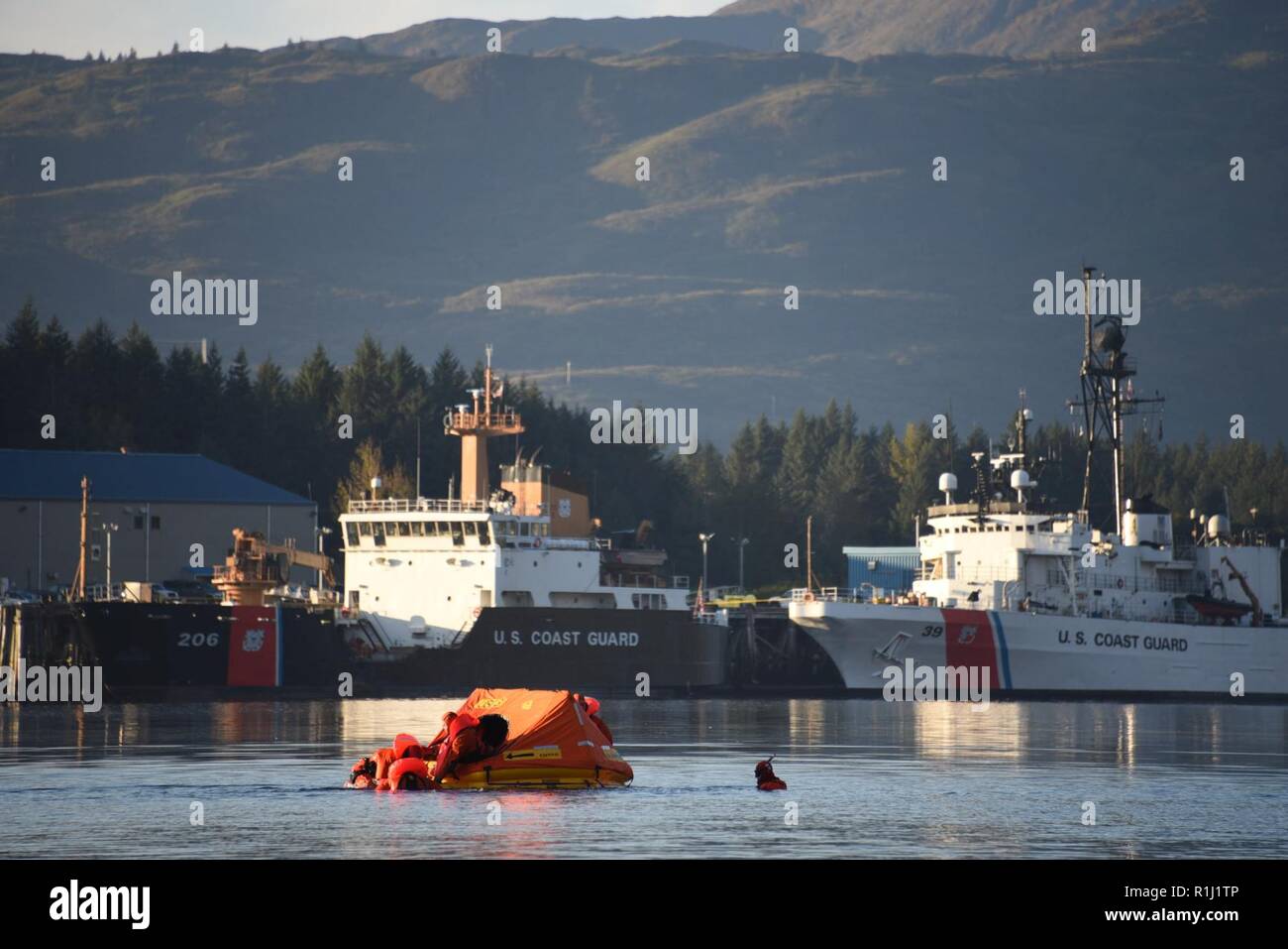 Coast Guard Air Station Kodiak aviators help one another into an ...