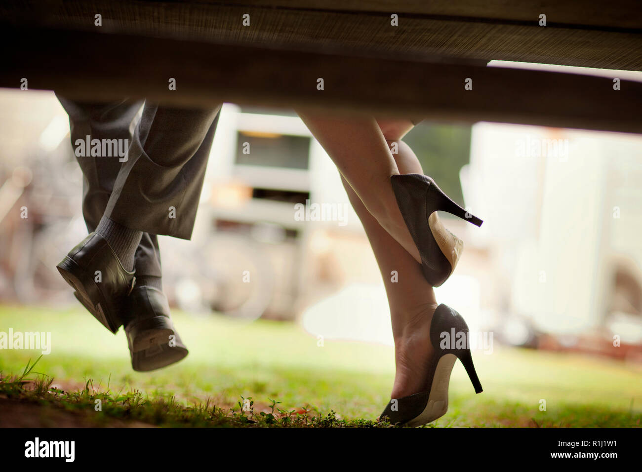 Dress shoes of a businessman and the high heels of his female colleague ...