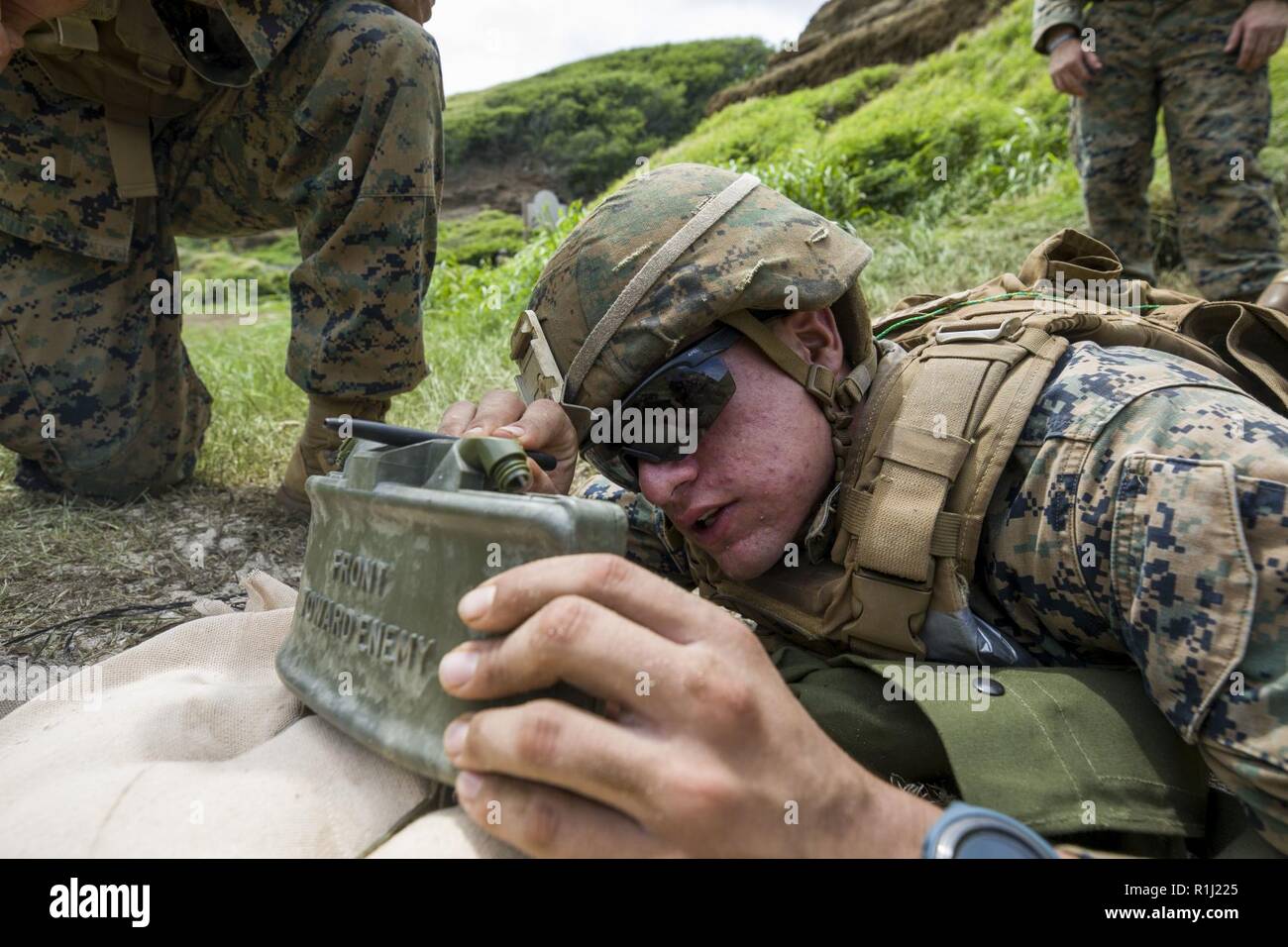 A U.S. Marine aims a M18A1 Claymore mine at targets during demolition ...