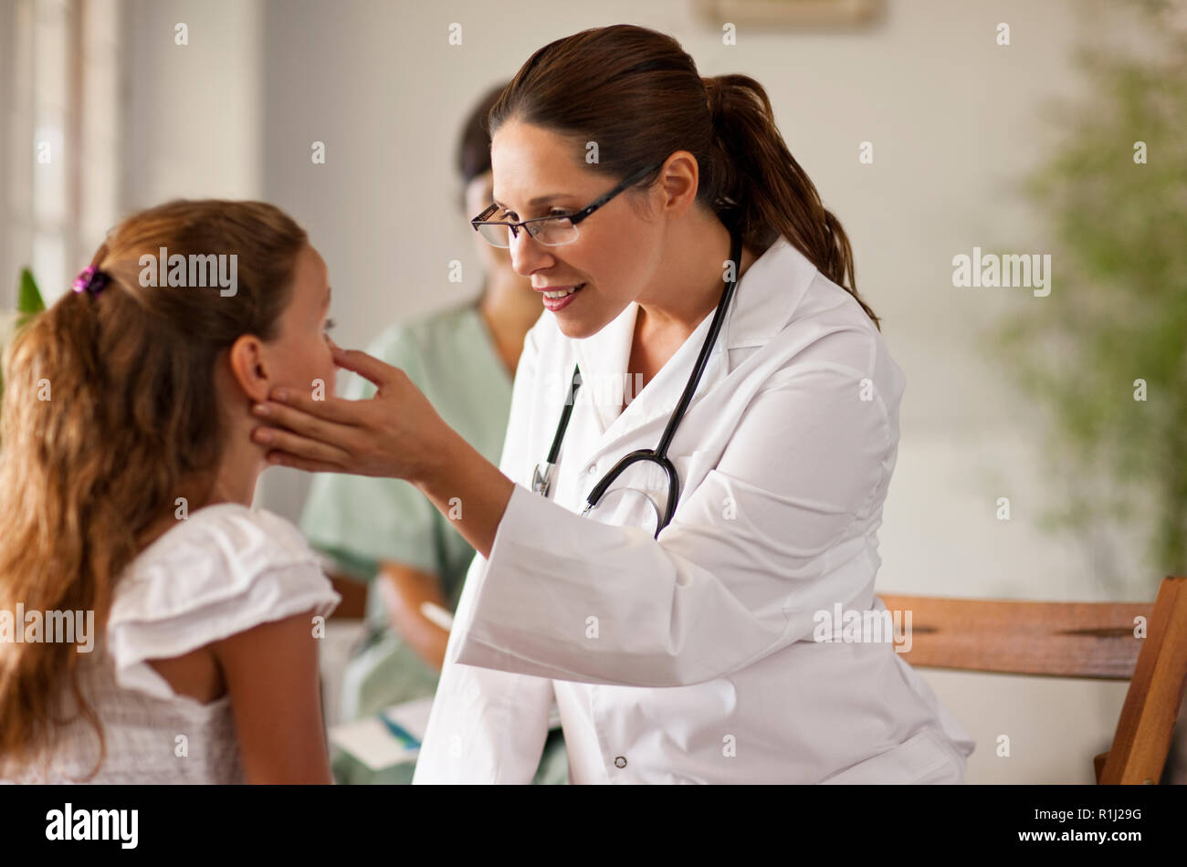 Friendly gentle female doctor examining young patient Stock Photo - Alamy
