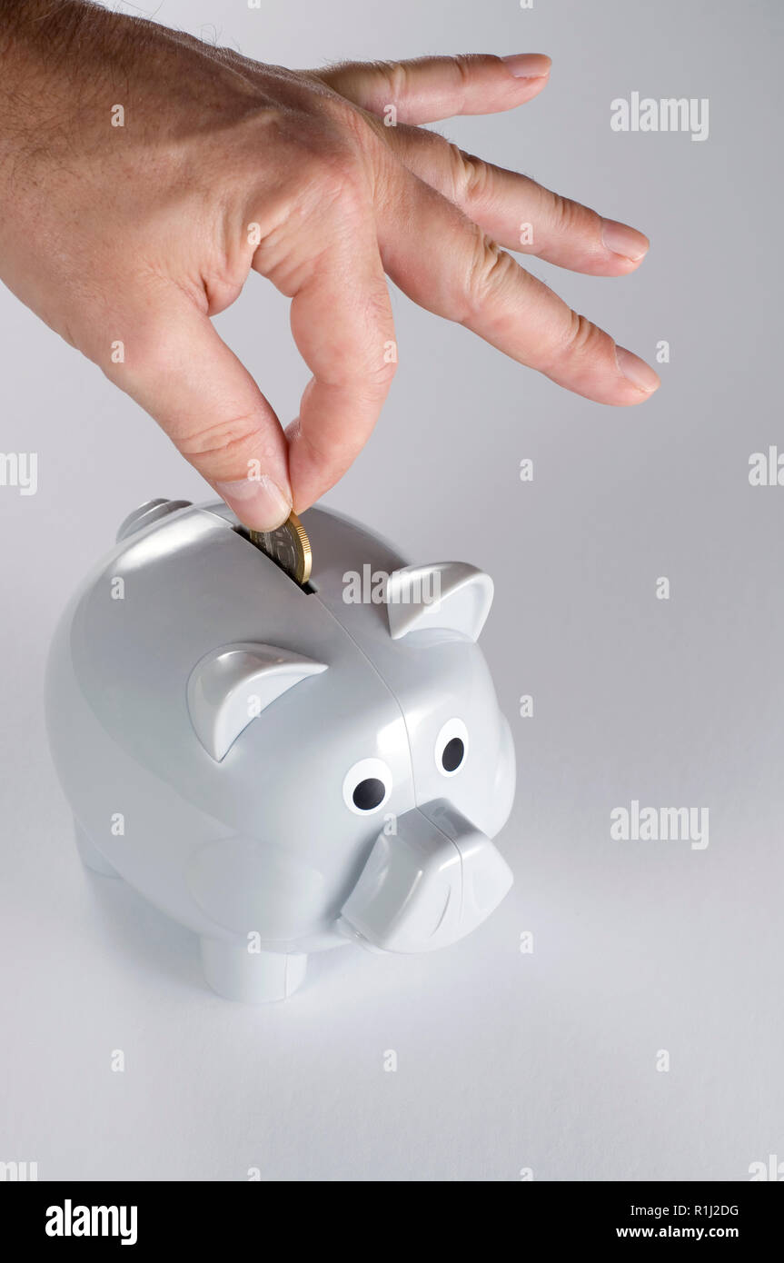 Man Depositing Coins in a Grey Piggy Bank Isolated on White Stock Photo ...