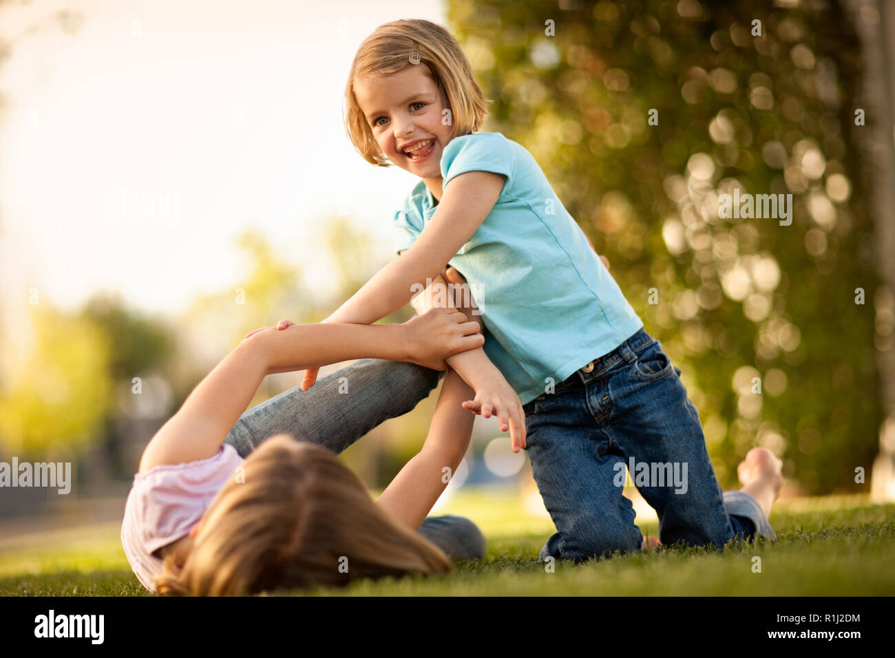 Two sisters playing in backyard Stock Photo - Alamy