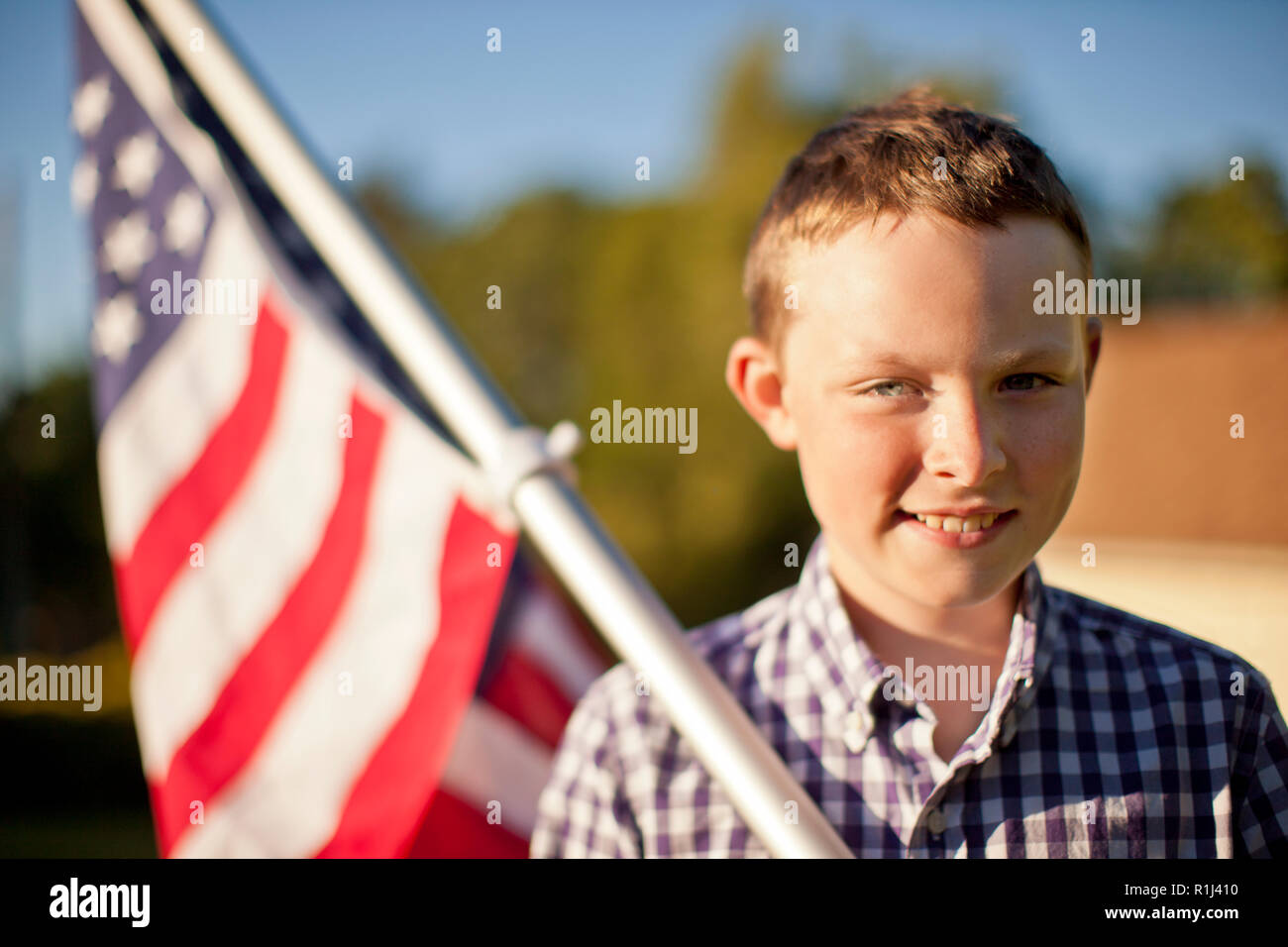 Portrait of a young boy holding an American flag Stock Photo - Alamy
