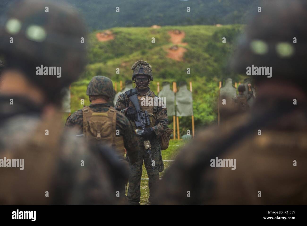 Lance Cpl. Michael Mathis stands on the firing line with an M16 rifle ...