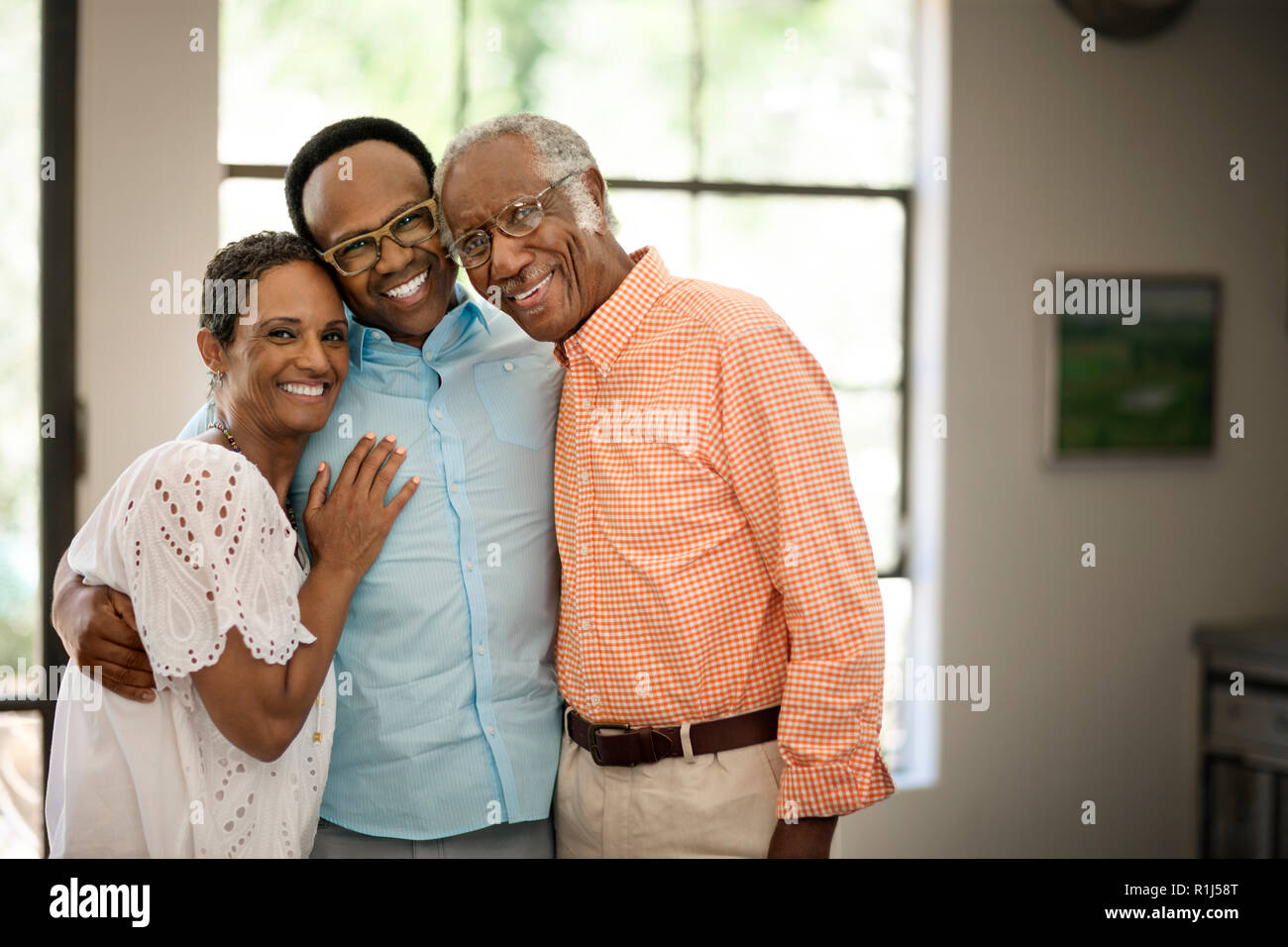 Adult son taking picture with his parents Stock Photo - Alamy