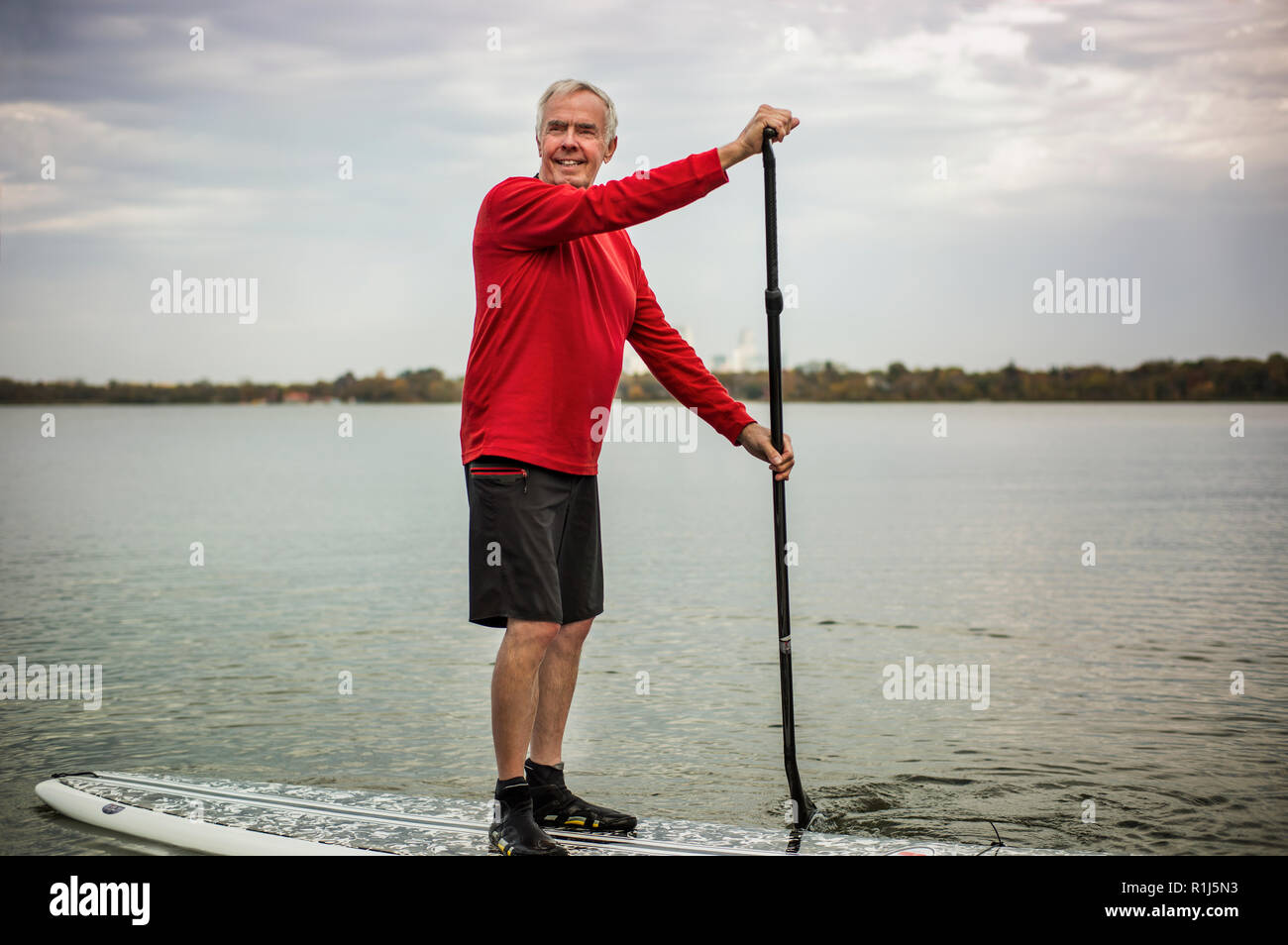 Senior man paddle boarding Stock Photo - Alamy