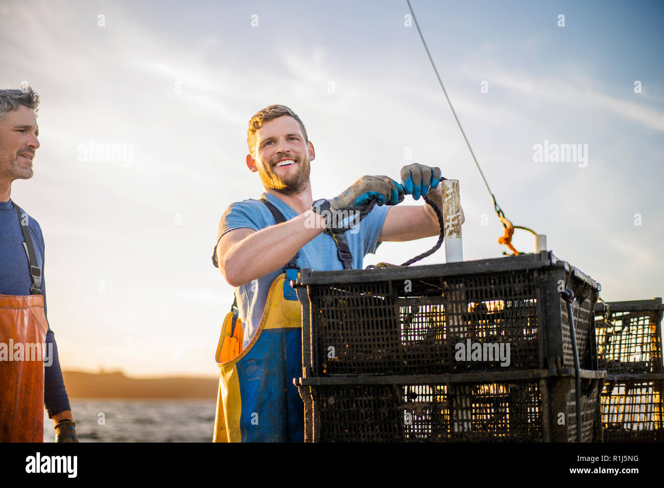 Father and son operating fishing business Stock Photo - Alamy