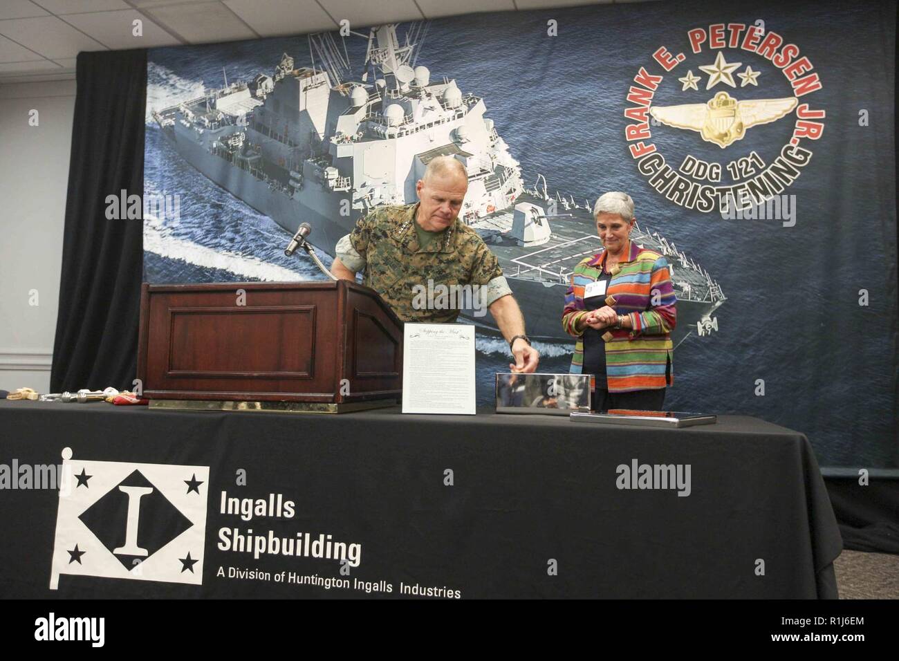 Commandant of the Marine Corps Gen. Robert B. Neller places a coin in a ...