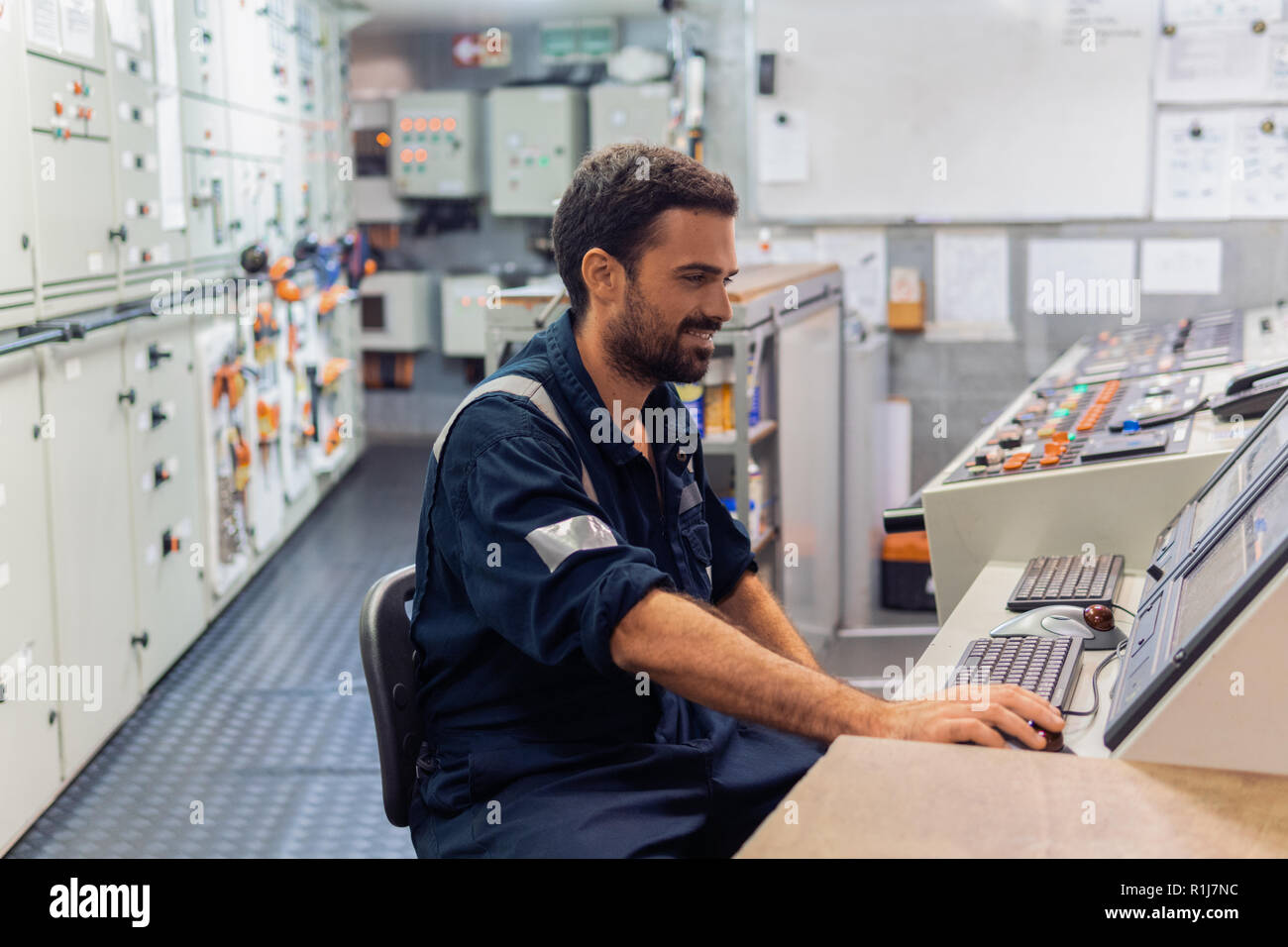 Marine engineer officer working in engine room Stock Photo - Alamy