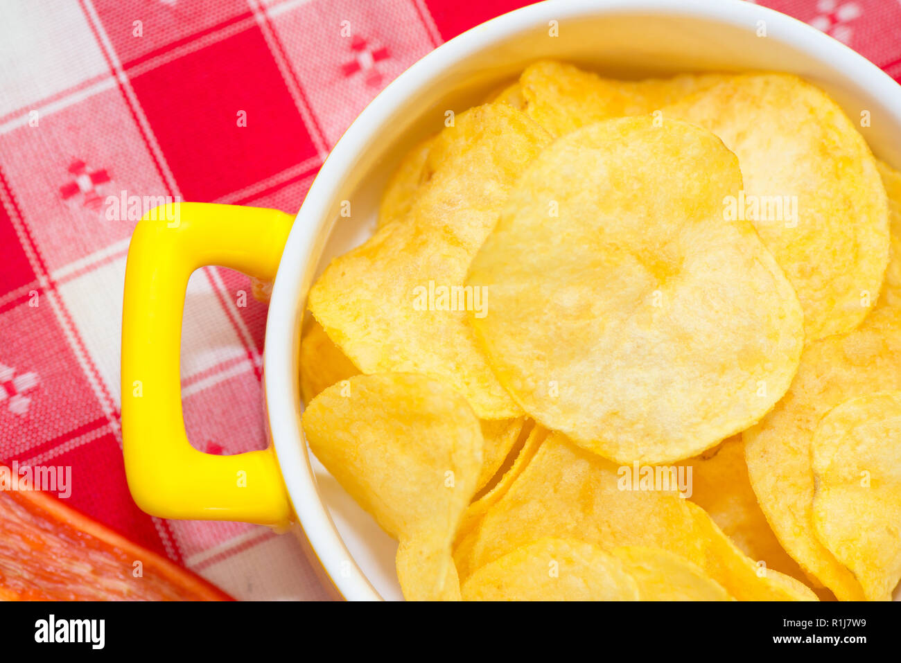 Chips in a yellow plate on a red background Stock Photo - Alamy