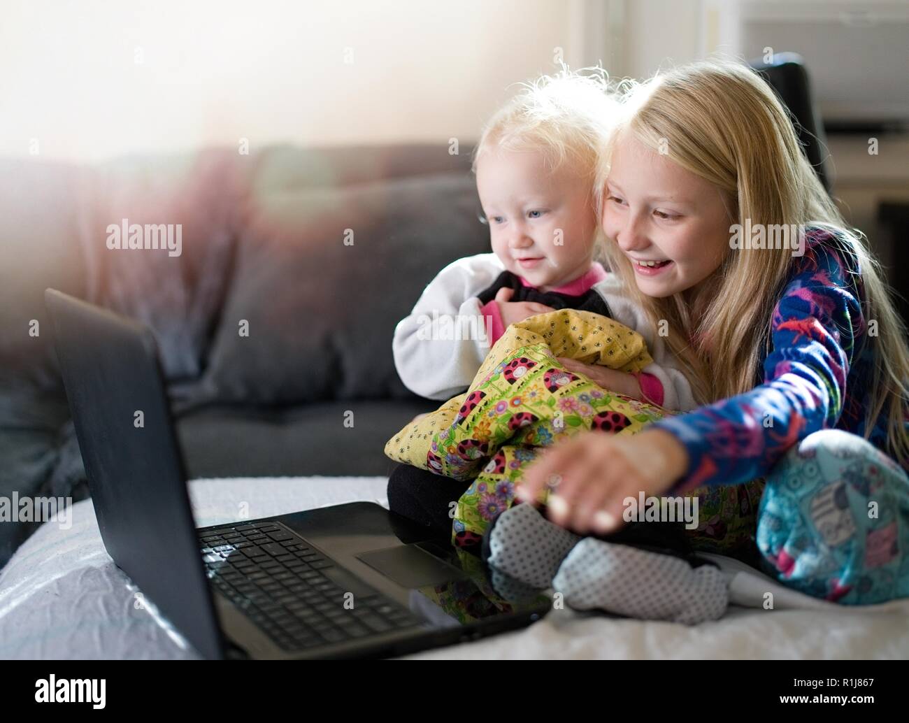 Two kids playing with laptop computer Stock Photo - Alamy