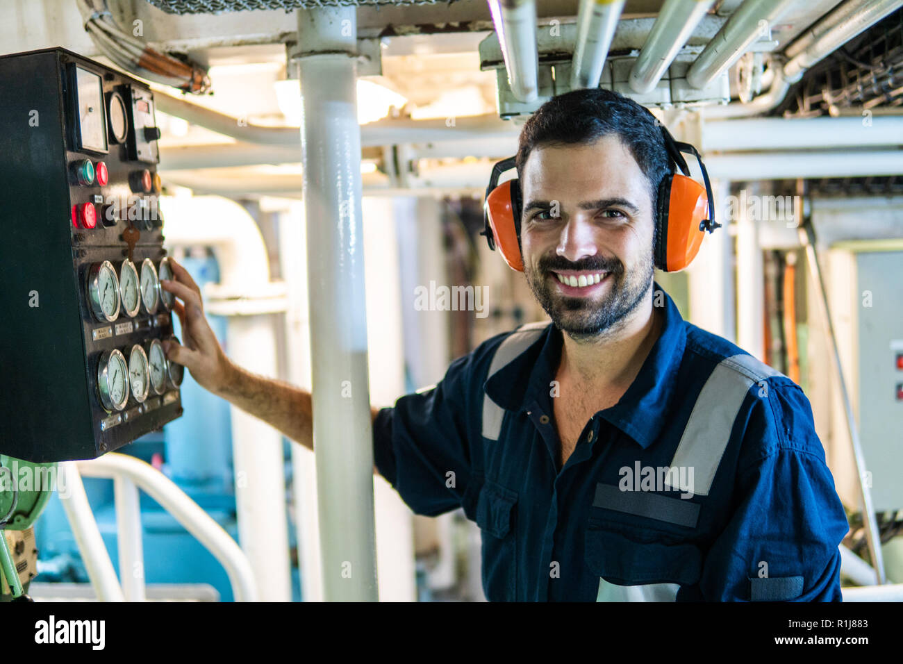 Marine engineer officer working in engine room Stock Photo - Alamy