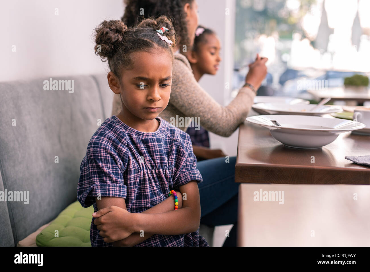 Little cute girl wearing bright bracelet feeling sad having no wish to ...