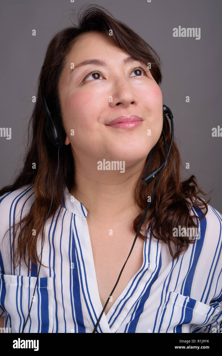 Portrait of Asian call center representative woman thinking Stock Photo ...