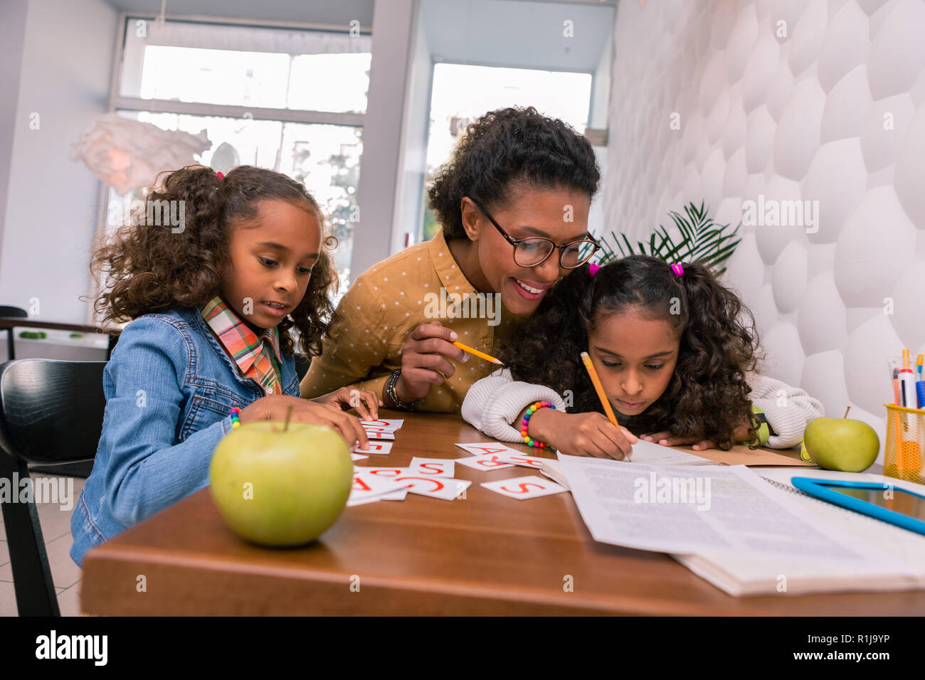 Smiling cheerful teacher feeling amazing while enjoying work with ...