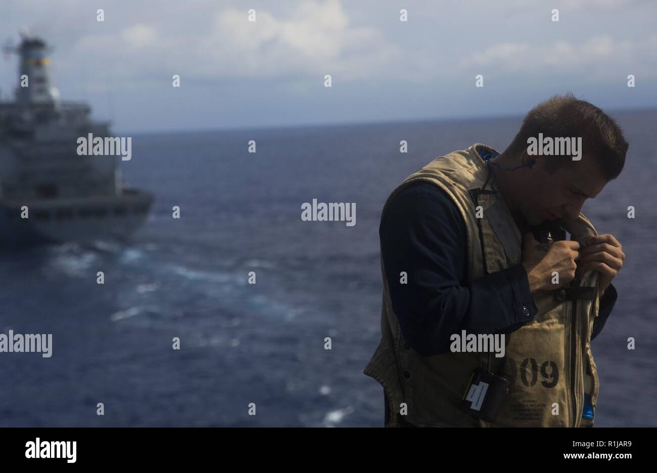 Petty Officer 1st Class Michael Sacco, communicates to the pilot house ...