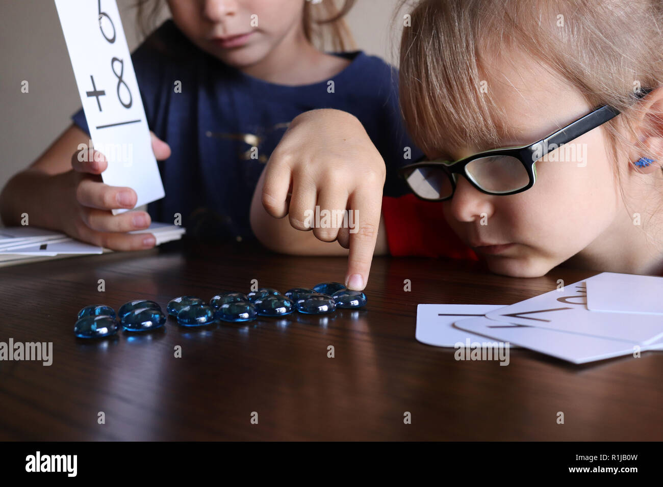 Older sister helping her little sister practice math at home Stock ...