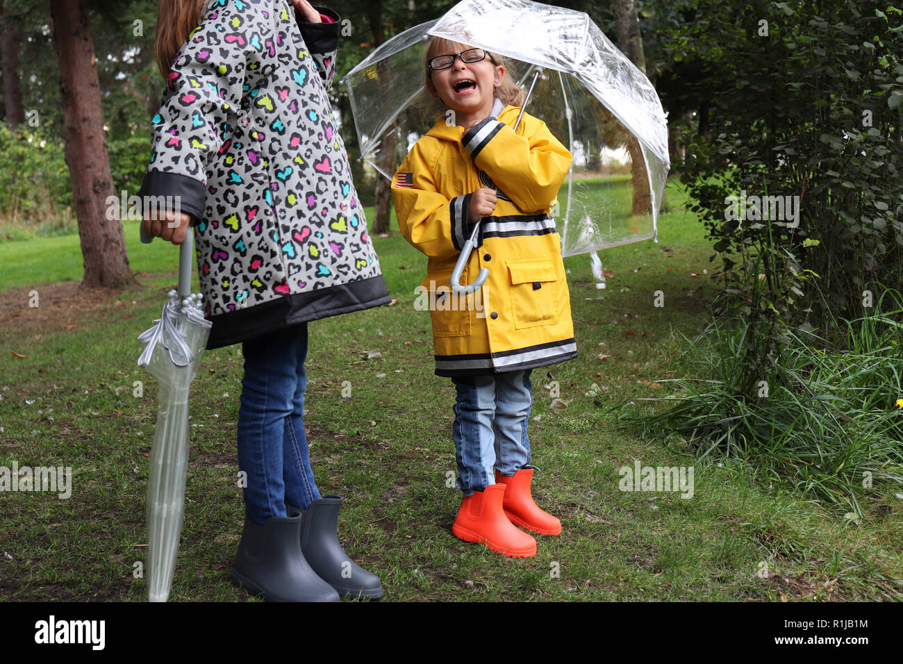 Two little girls enjoying the cold, cloudy weather outside Stock Photo ...