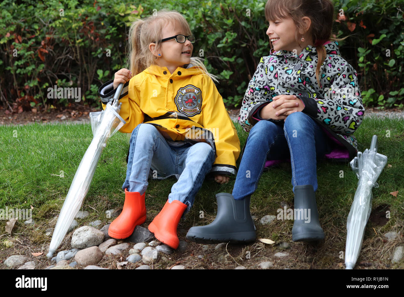 Two little girls enjoying the cold, cloudy weather outside Stock Photo ...