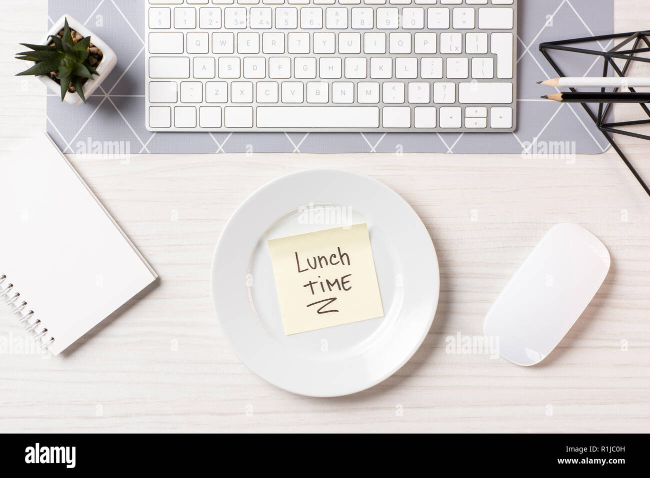 top view of note with inscription lunch time on plate, computer mouse ...