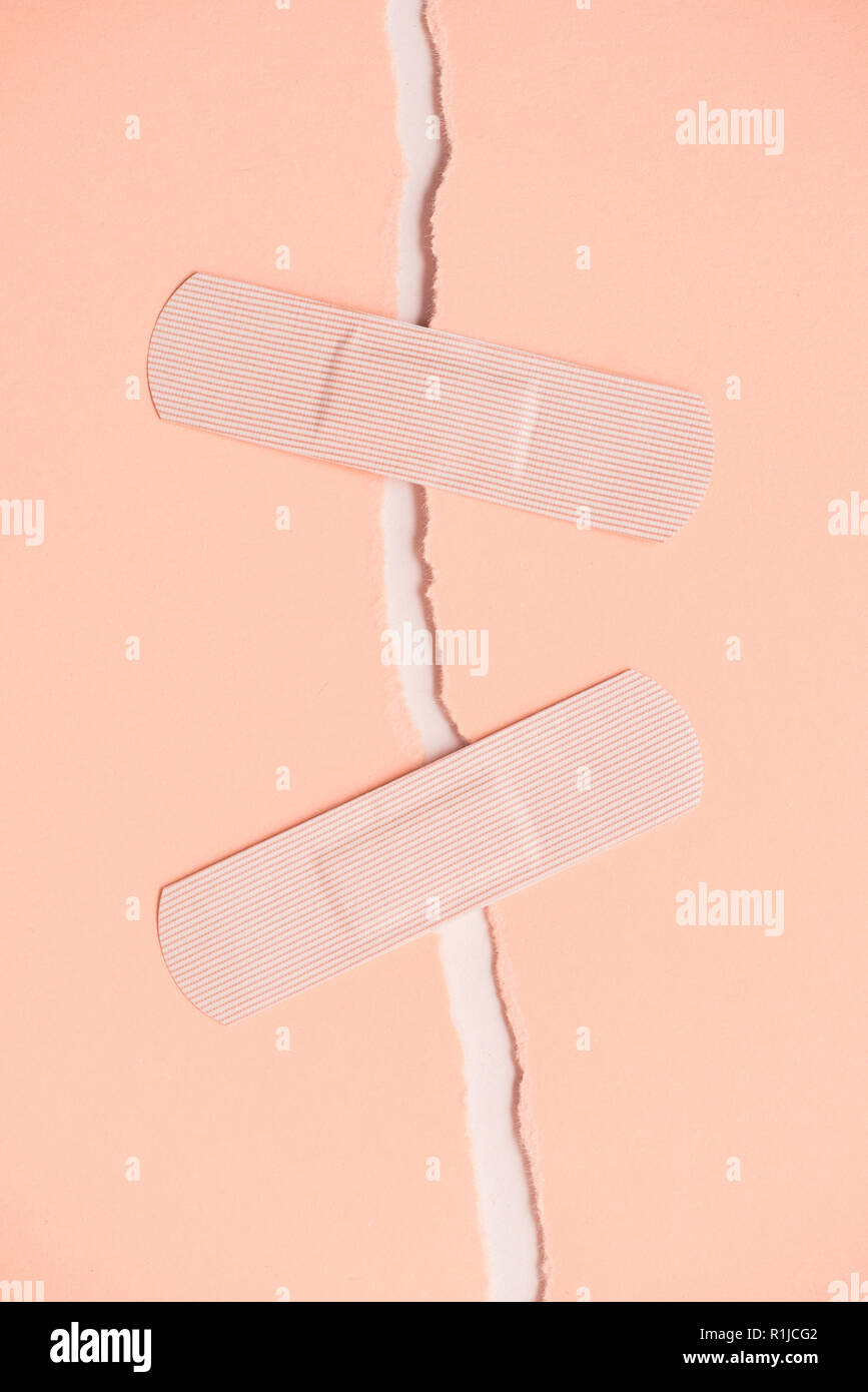 top view of adhesive bandages holding two parts of torn paper Stock ...