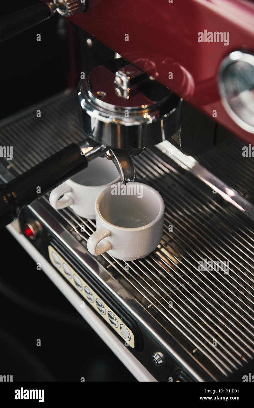 high angle view of coffee machine and two mugs with espresso in ...