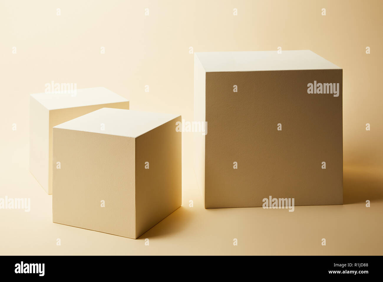 still life of cubes in different sizes on beige surface Stock Photo - Alamy
