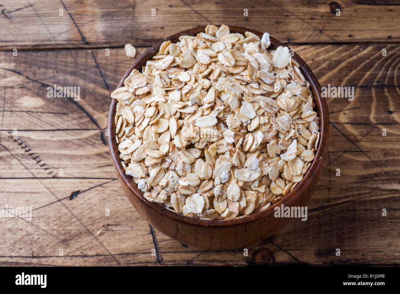 Oatmeal raw in a wooden bowl on a rustic wooden background Stock Photo ...