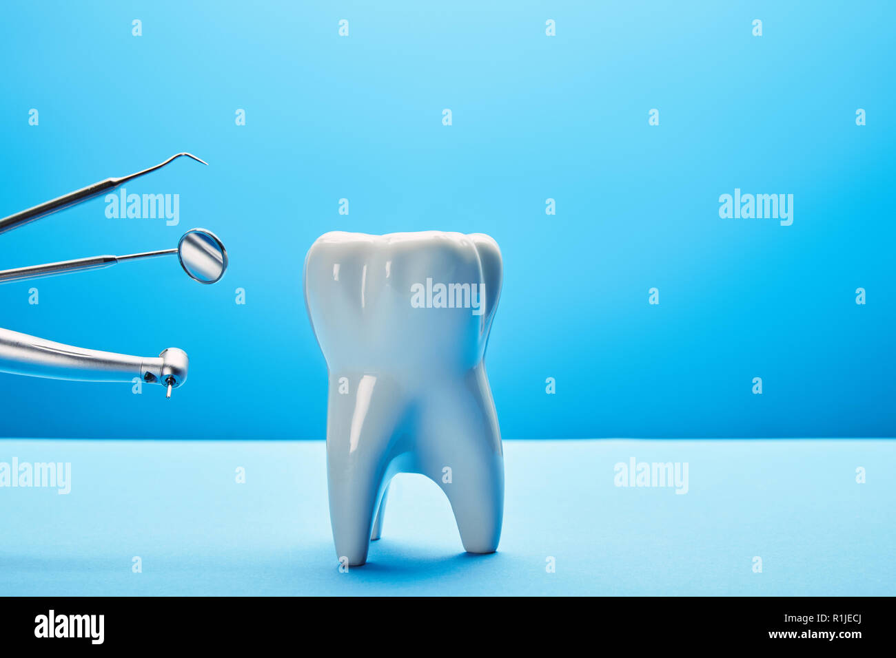close up view of white tooth model and stainless dental instruments on ...