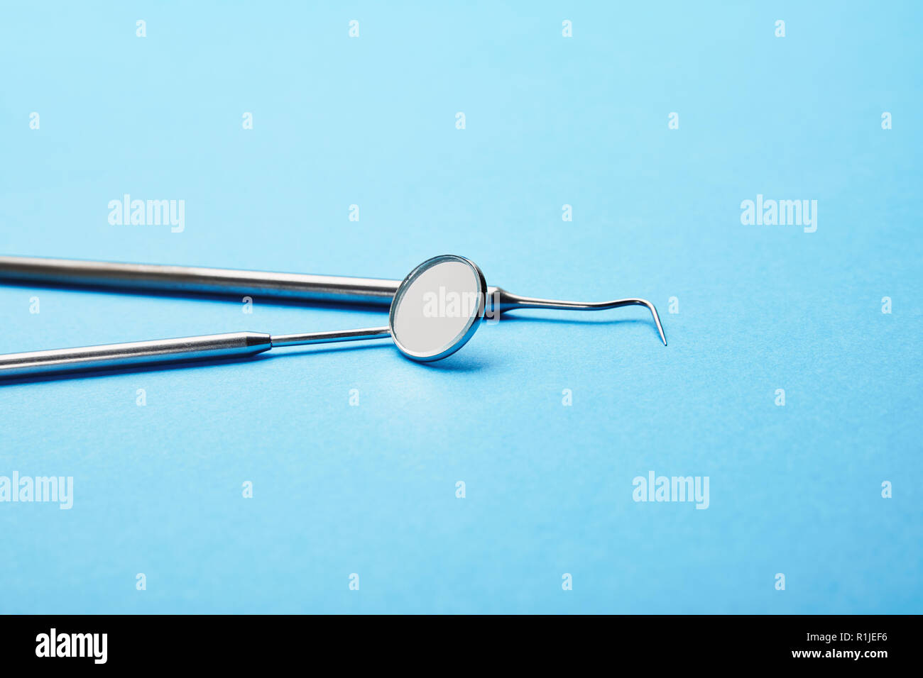 close up view of dental mouth mirror and probe on blue surface Stock ...