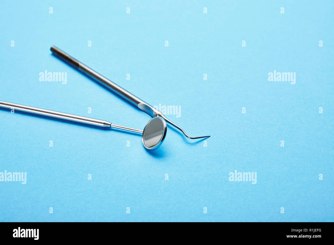 close up view of dental mouth mirror and probe on blue surface Stock ...