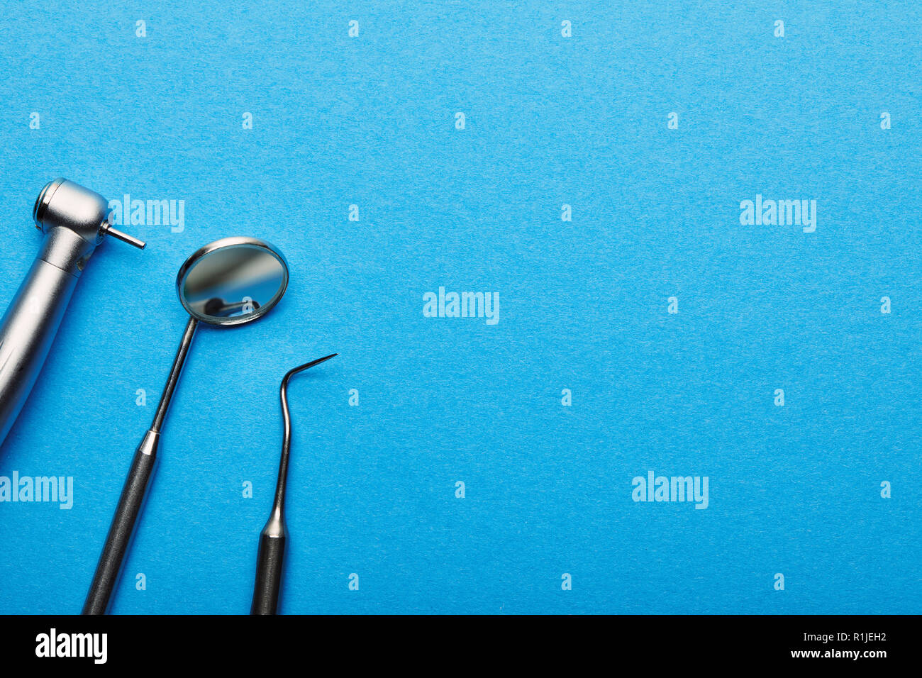 flat lay with arranged stainless dental instruments on blue tabletop ...
