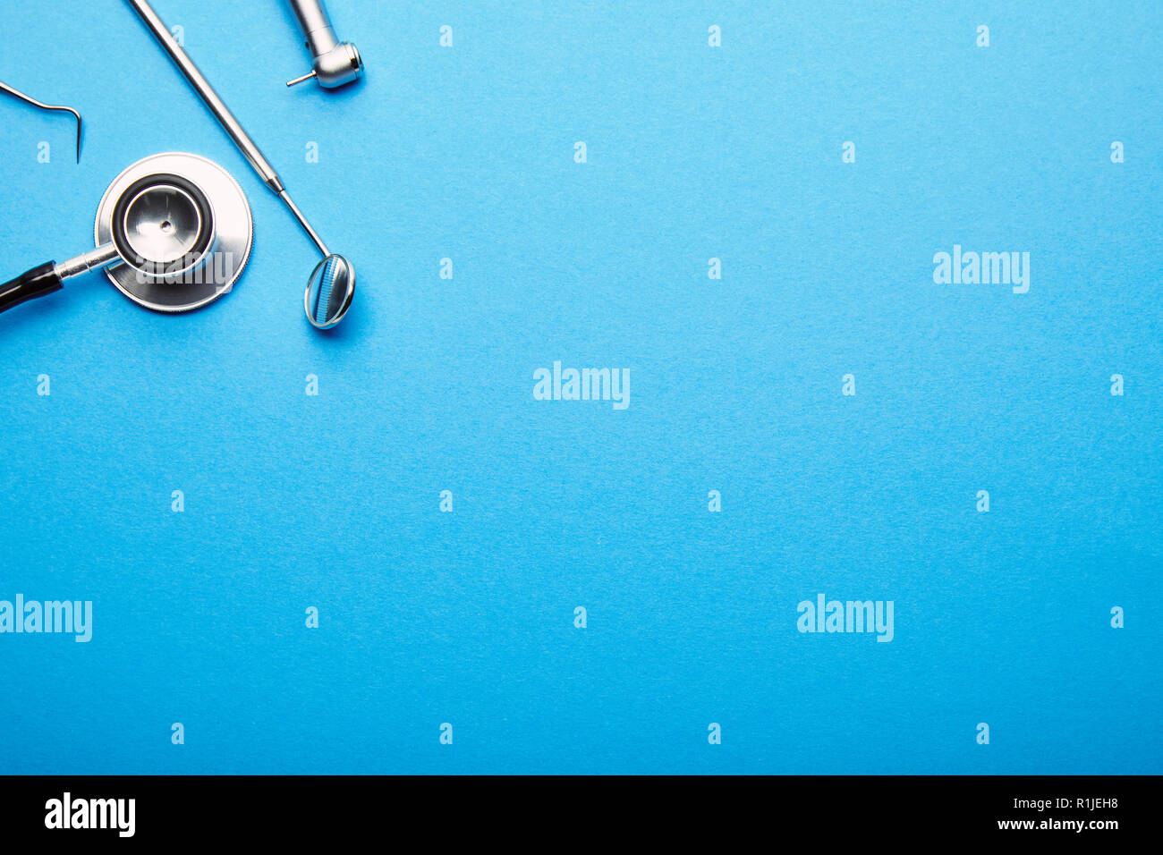 flat lay with arranged stainless dental instruments on blue tabletop ...
