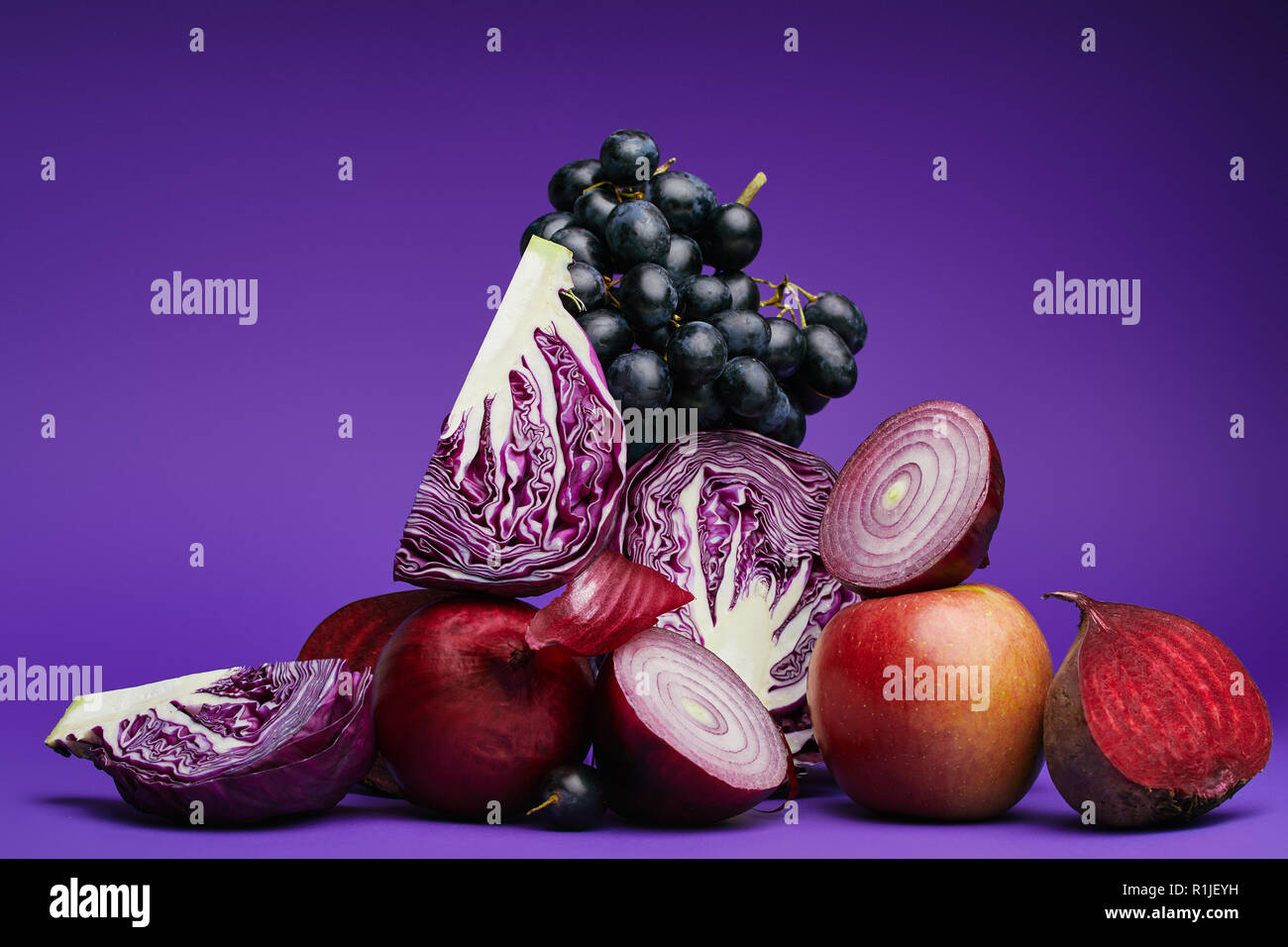 close-up view of grapes, apple, beetroot, onions and sliced cabbage on ...