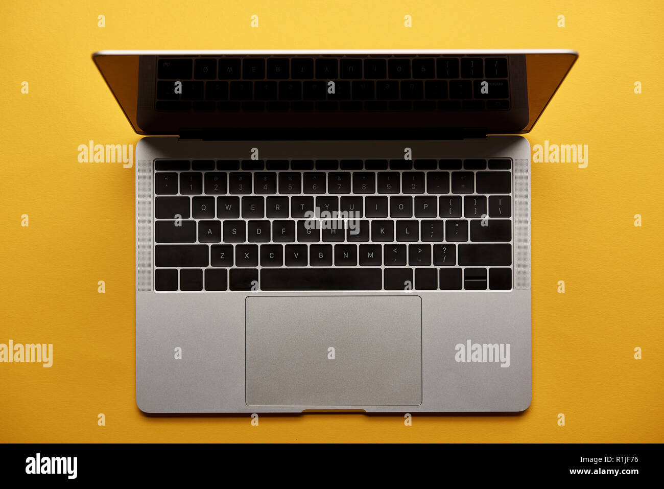 top view of opened laptop on yellow surface Stock Photo - Alamy