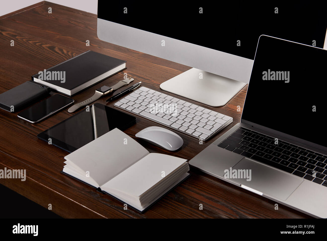 modern workplace with various devices on wooden table Stock Photo - Alamy
