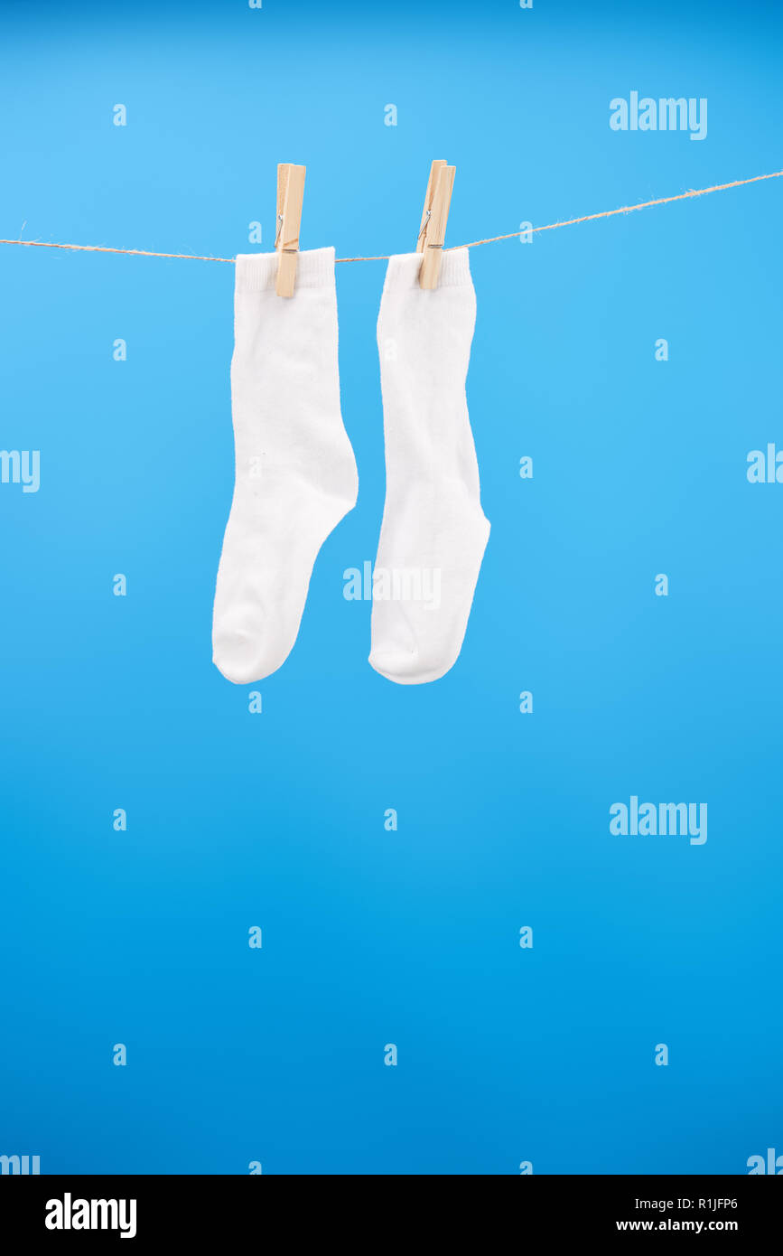 close-up view of clean white socks hanging on clothesline isolated on ...