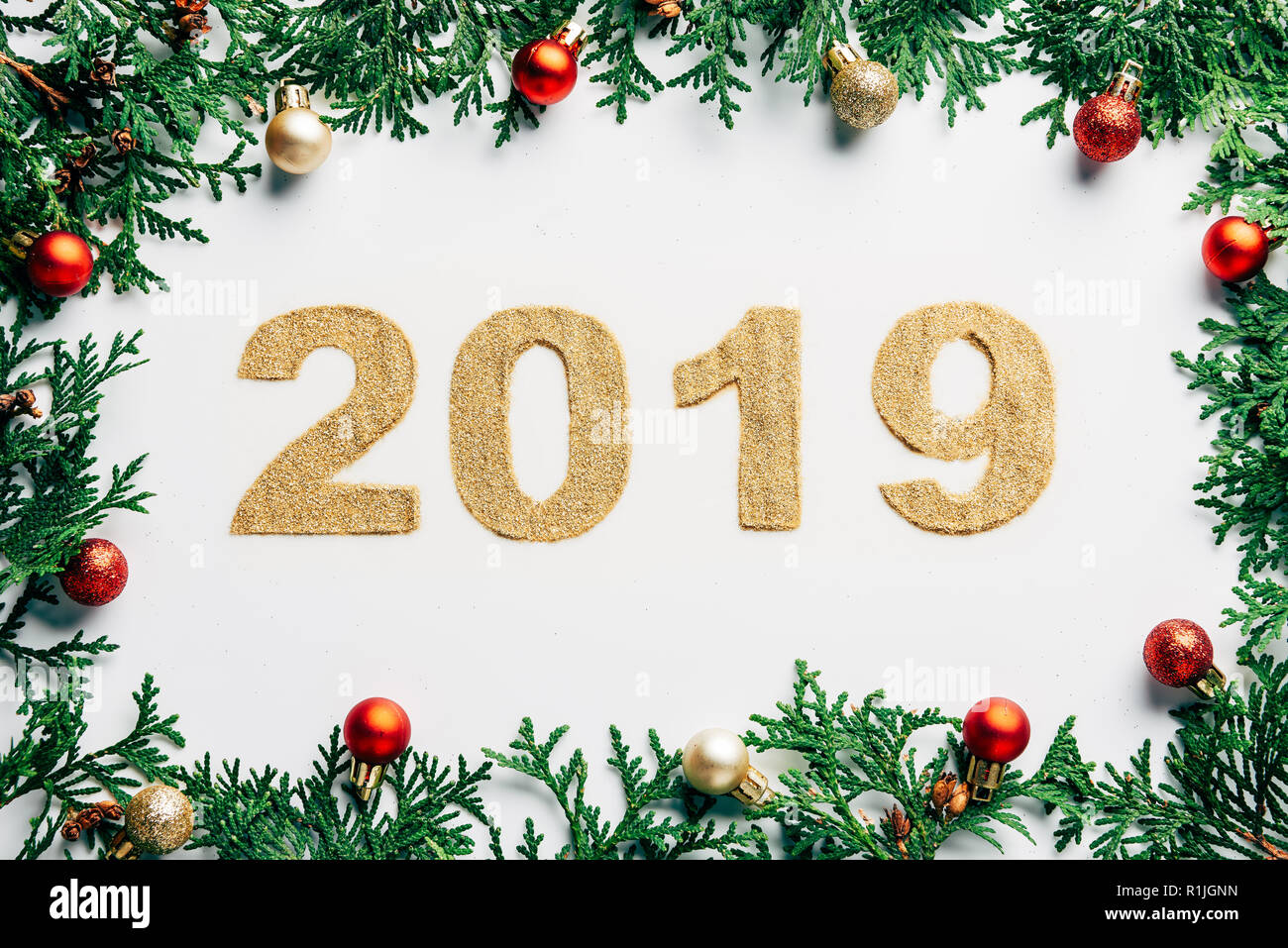 top view of 2019 year sign, pine tree branches and christmas balls on ...