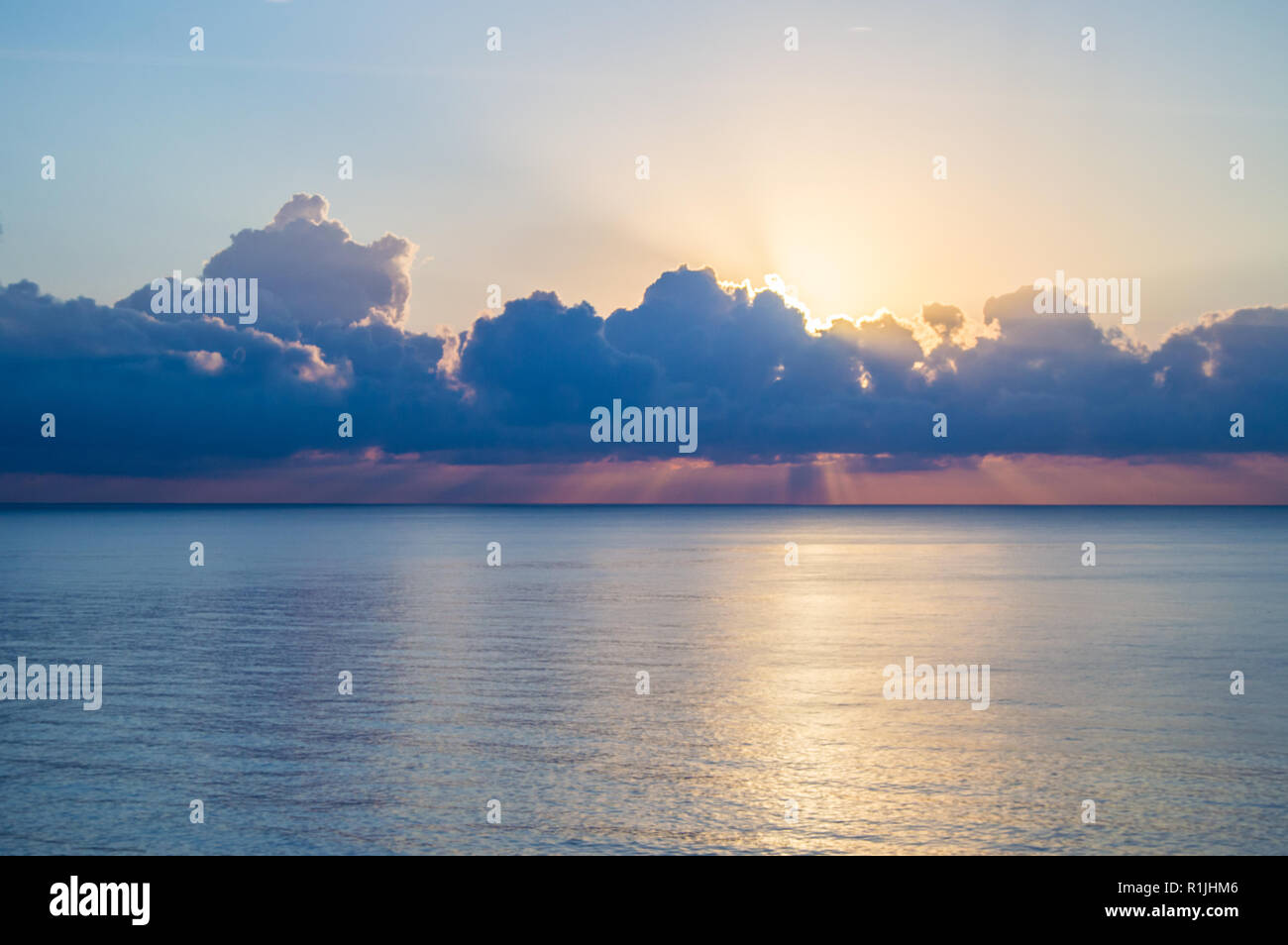 Beautiful sunset and silver path on the sea, blue clouds in the sky ...