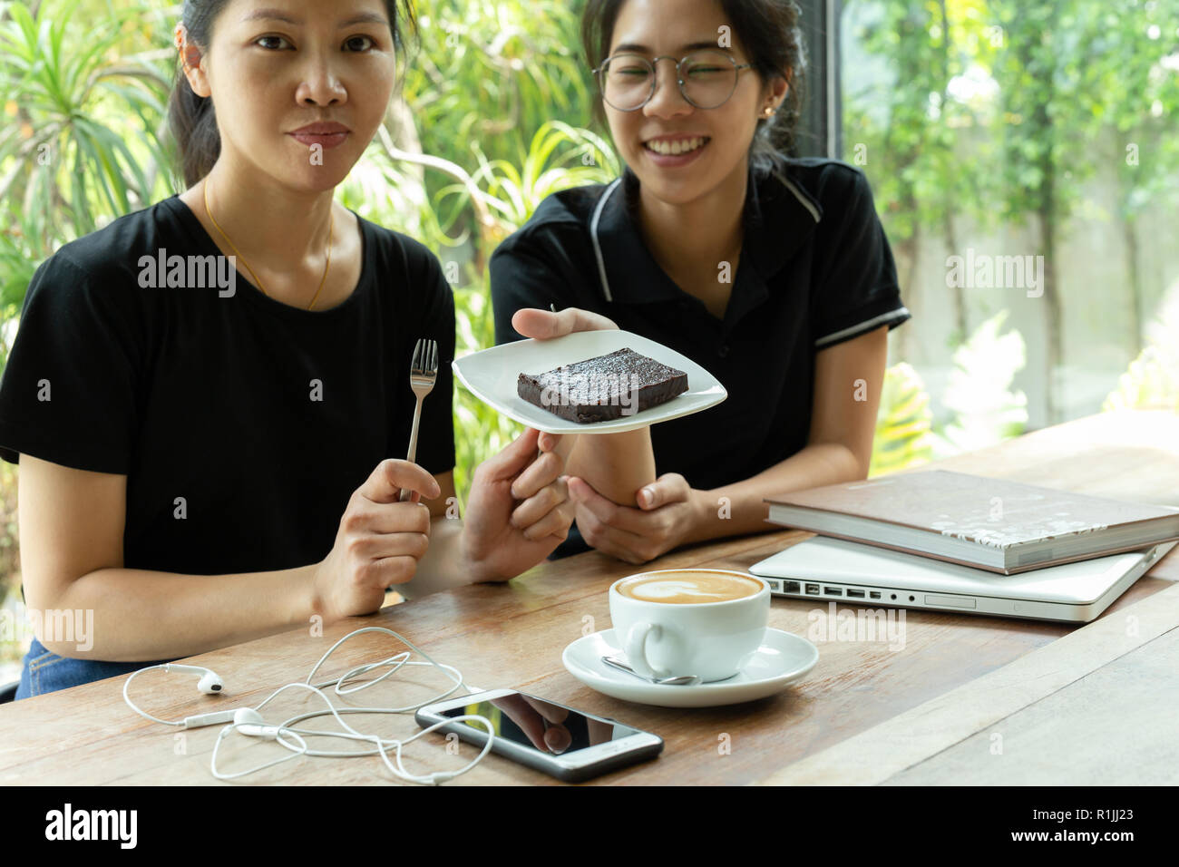 Female friends having coffee break with brownie cake in coffee shop ...